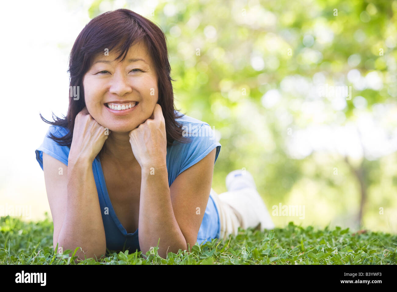Woman relaxing outdoors smiling Stock Photo - Alamy