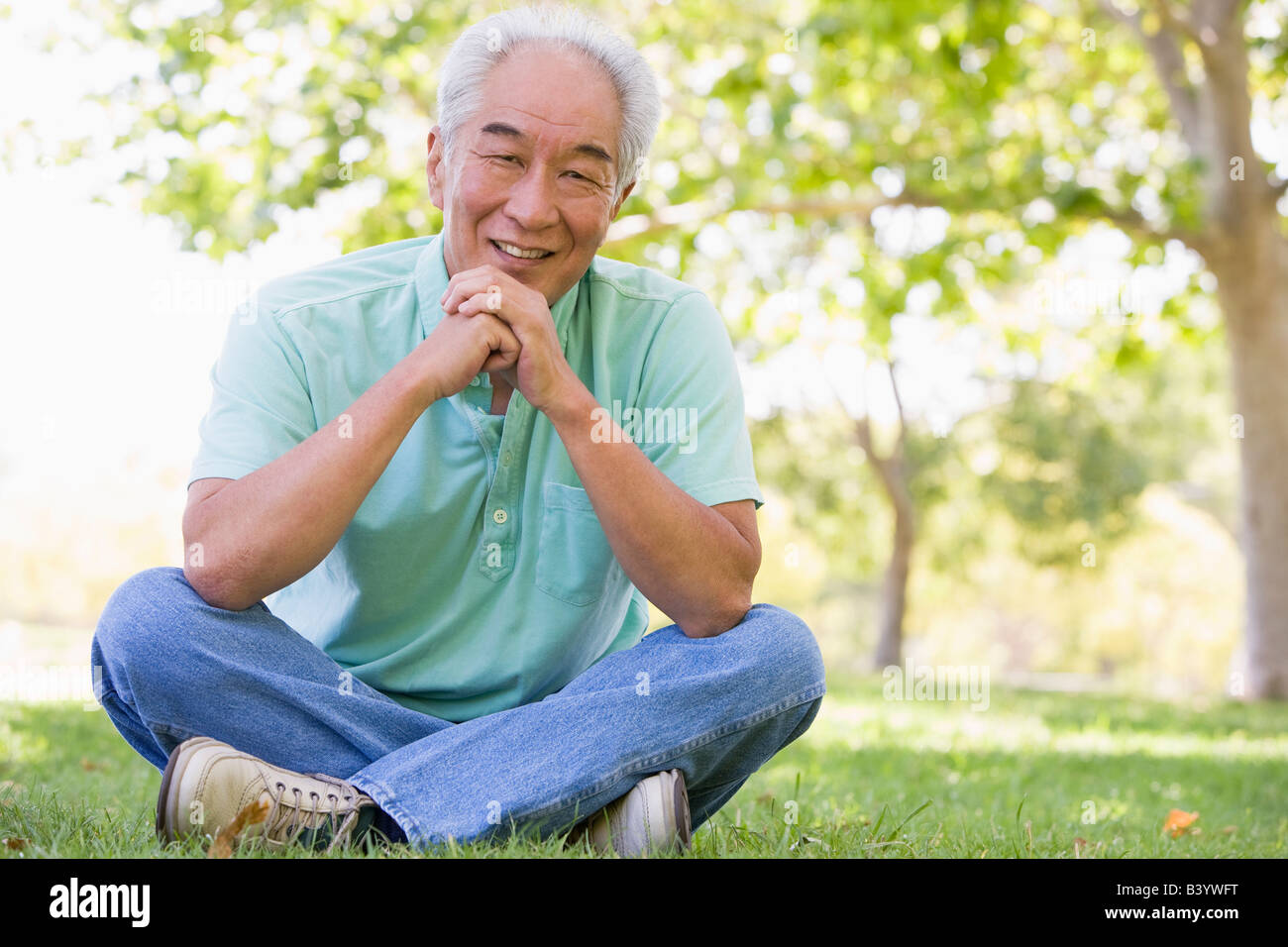 Man sitting outdoors smiling Stock Photo - Alamy