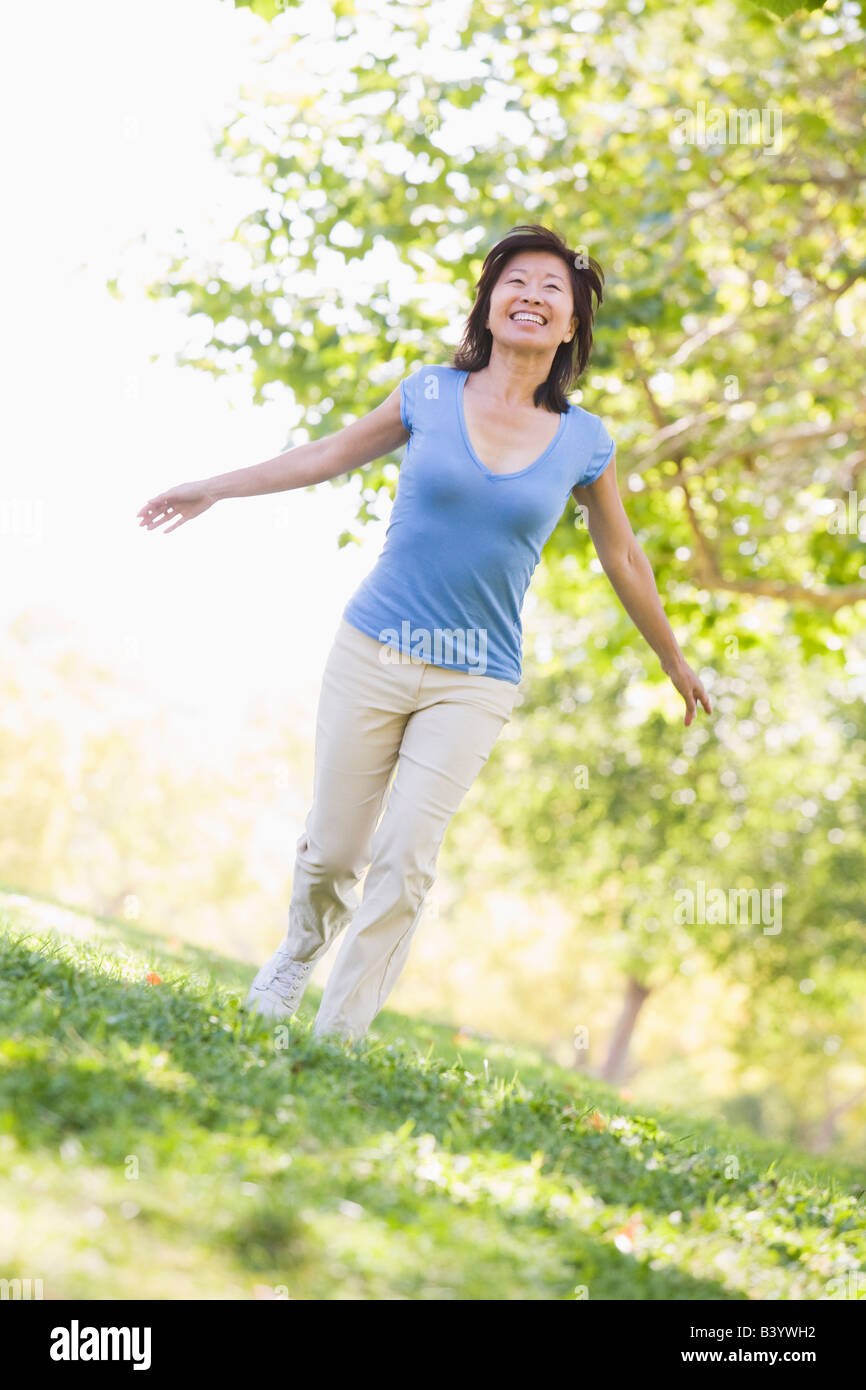 Woman walking outdoors smiling Stock Photo - Alamy