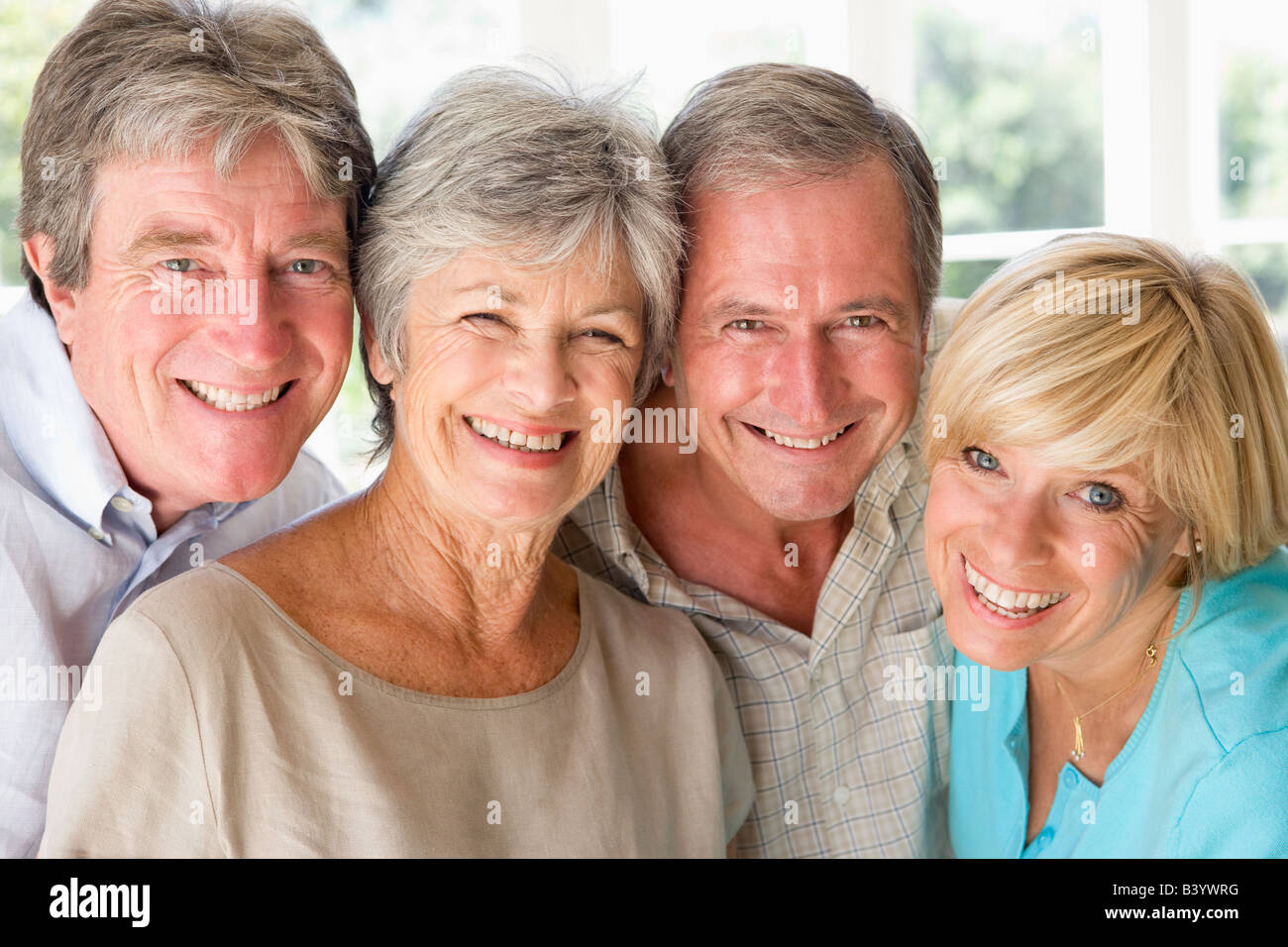 Two couples indoors smiling Stock Photo - Alamy
