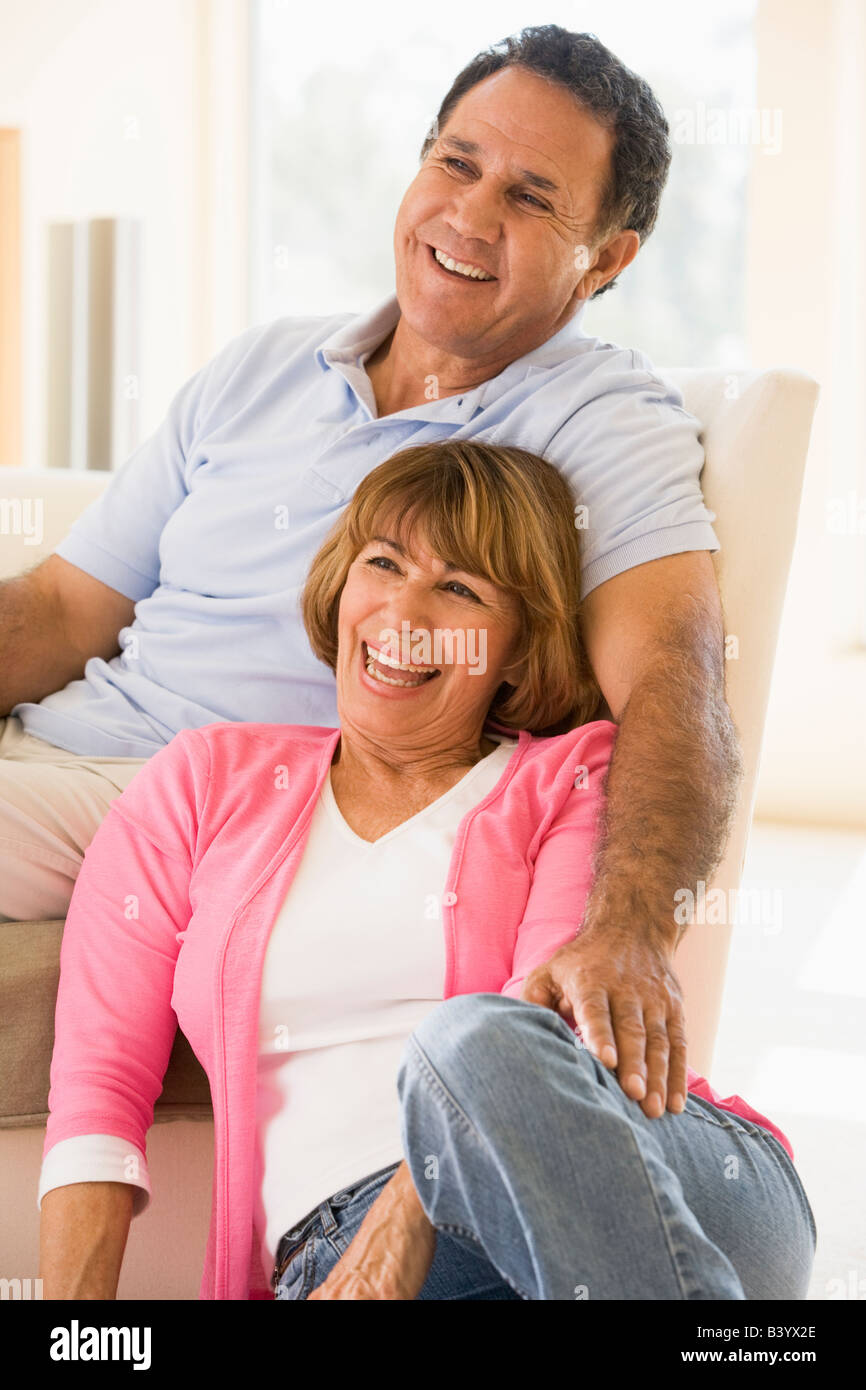 Couple in living room smiling Stock Photo - Alamy