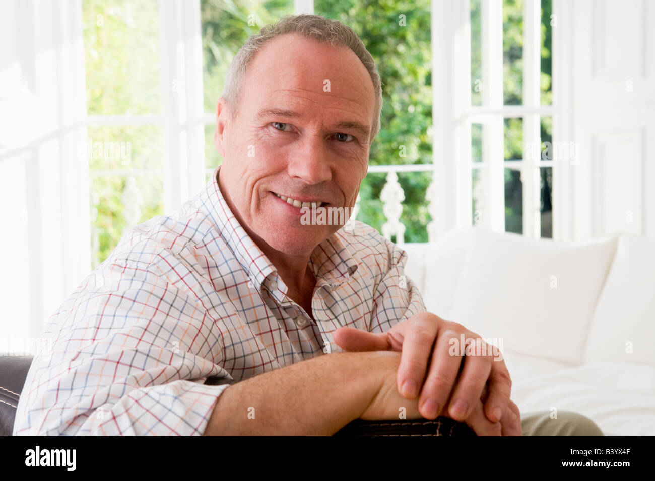 Man in living room smiling Stock Photo - Alamy