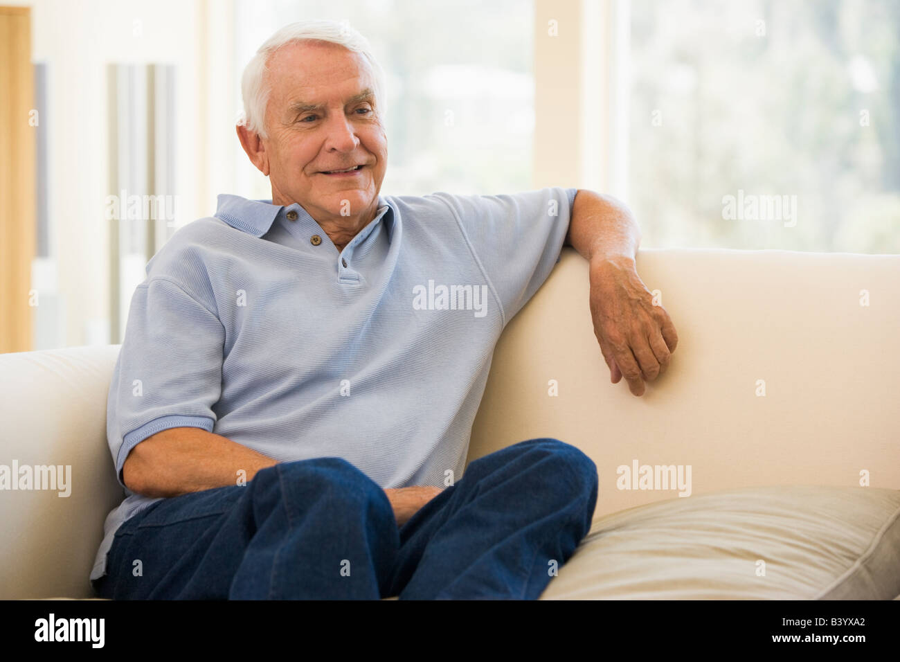 Man sitting in living room smiling Stock Photo - Alamy