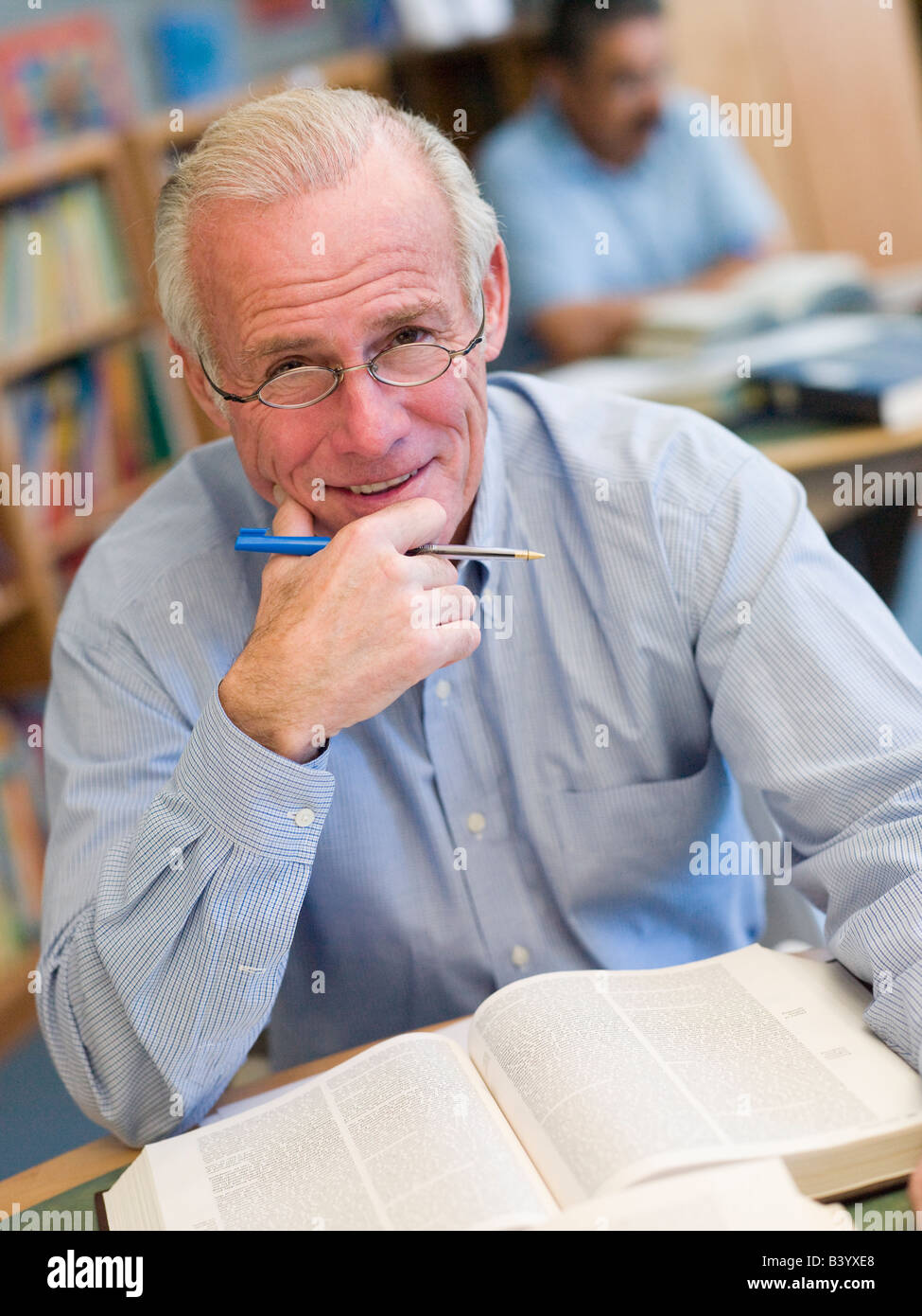 Man in library with pen and book (selective focus Stock Photo - Alamy