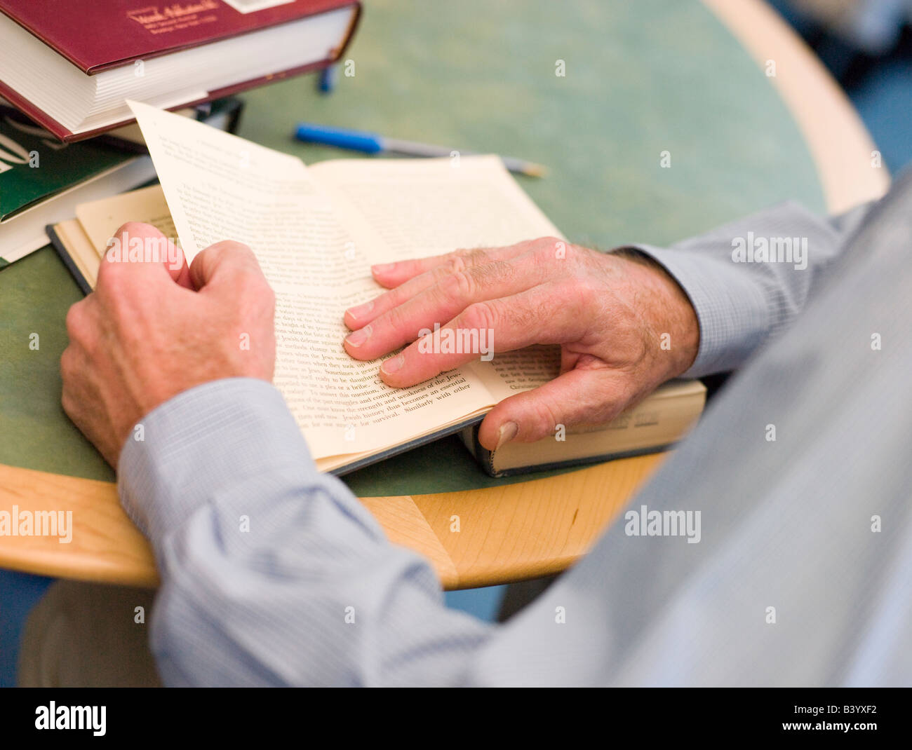 Man at table reading a book (selective focus Stock Photo - Alamy