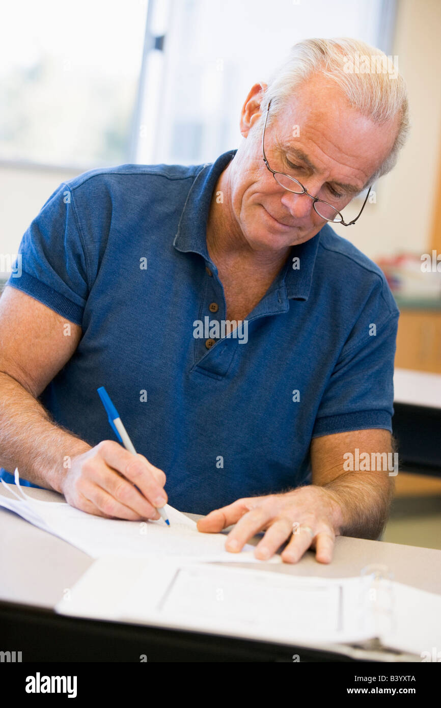 Adult student in class taking notes Stock Photo - Alamy