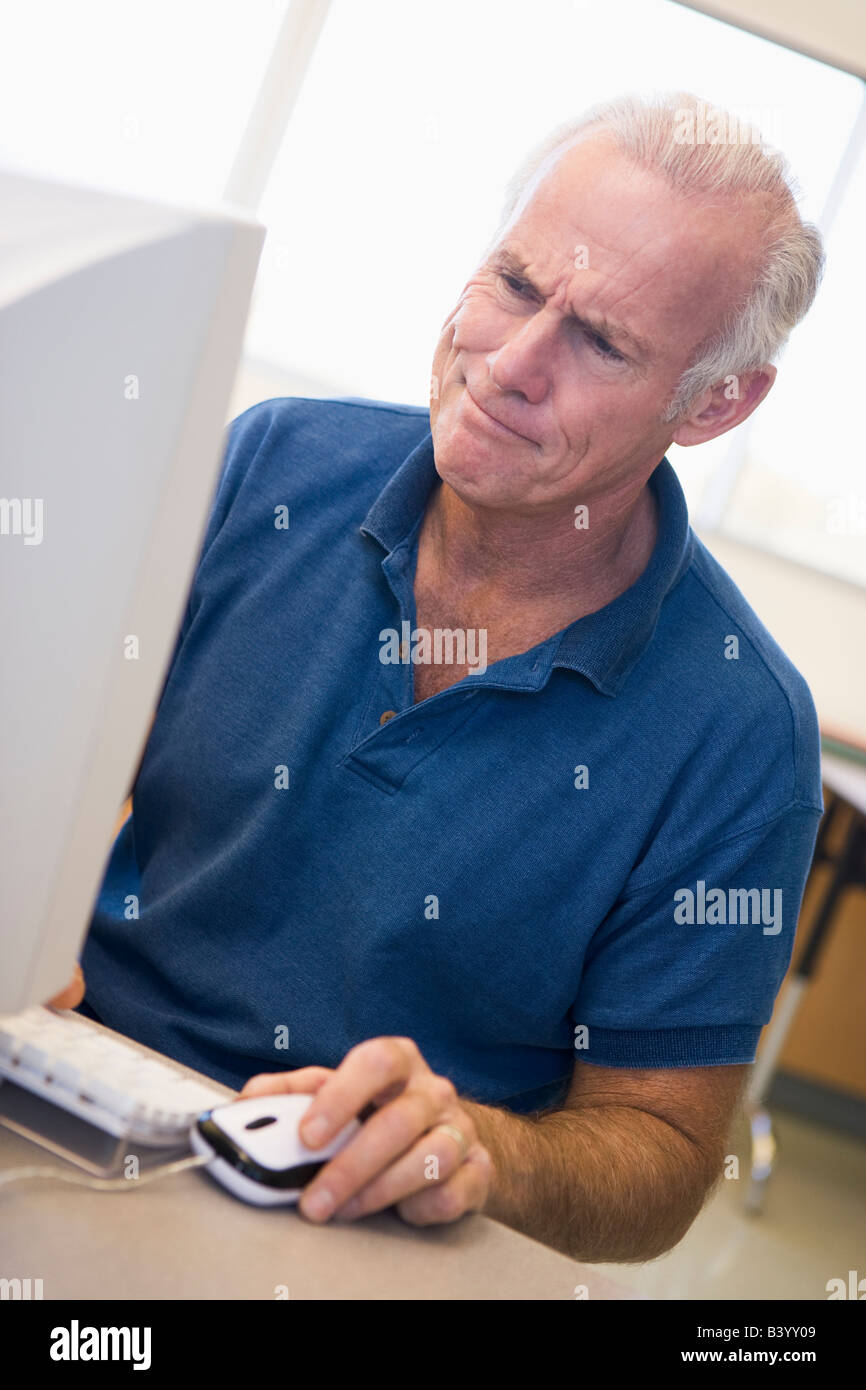 Man at computer looking at monitor confused (high key Stock Photo - Alamy