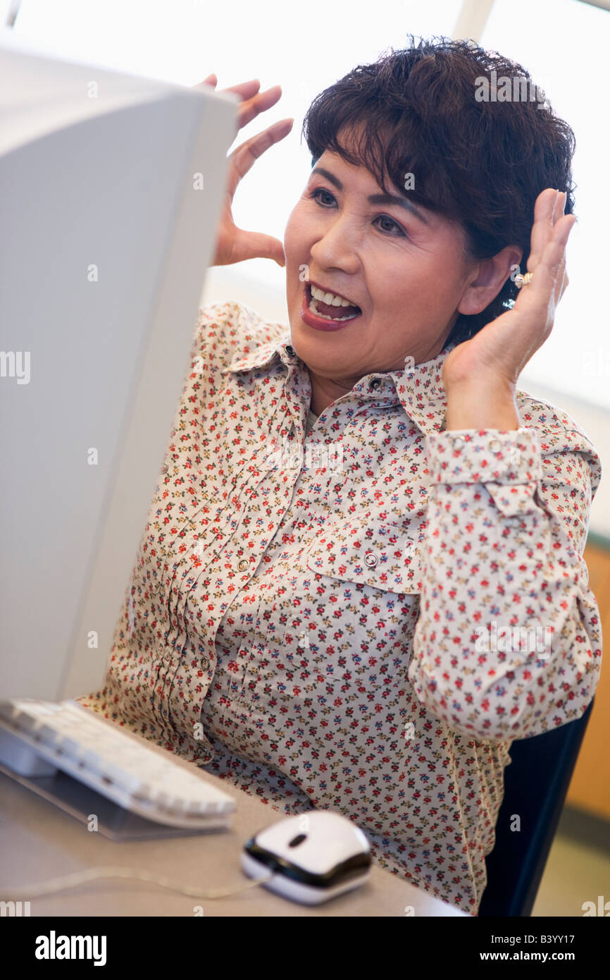 Woman at computer looking at monitor surprised (high key Stock Photo ...