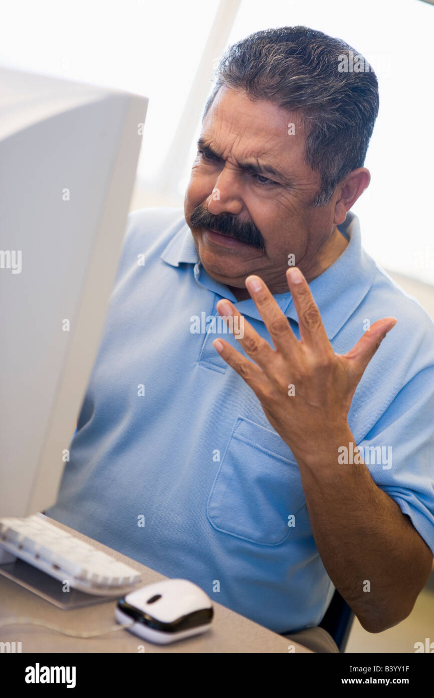 Man at computer looking at monitor frustrated (high key Stock Photo - Alamy
