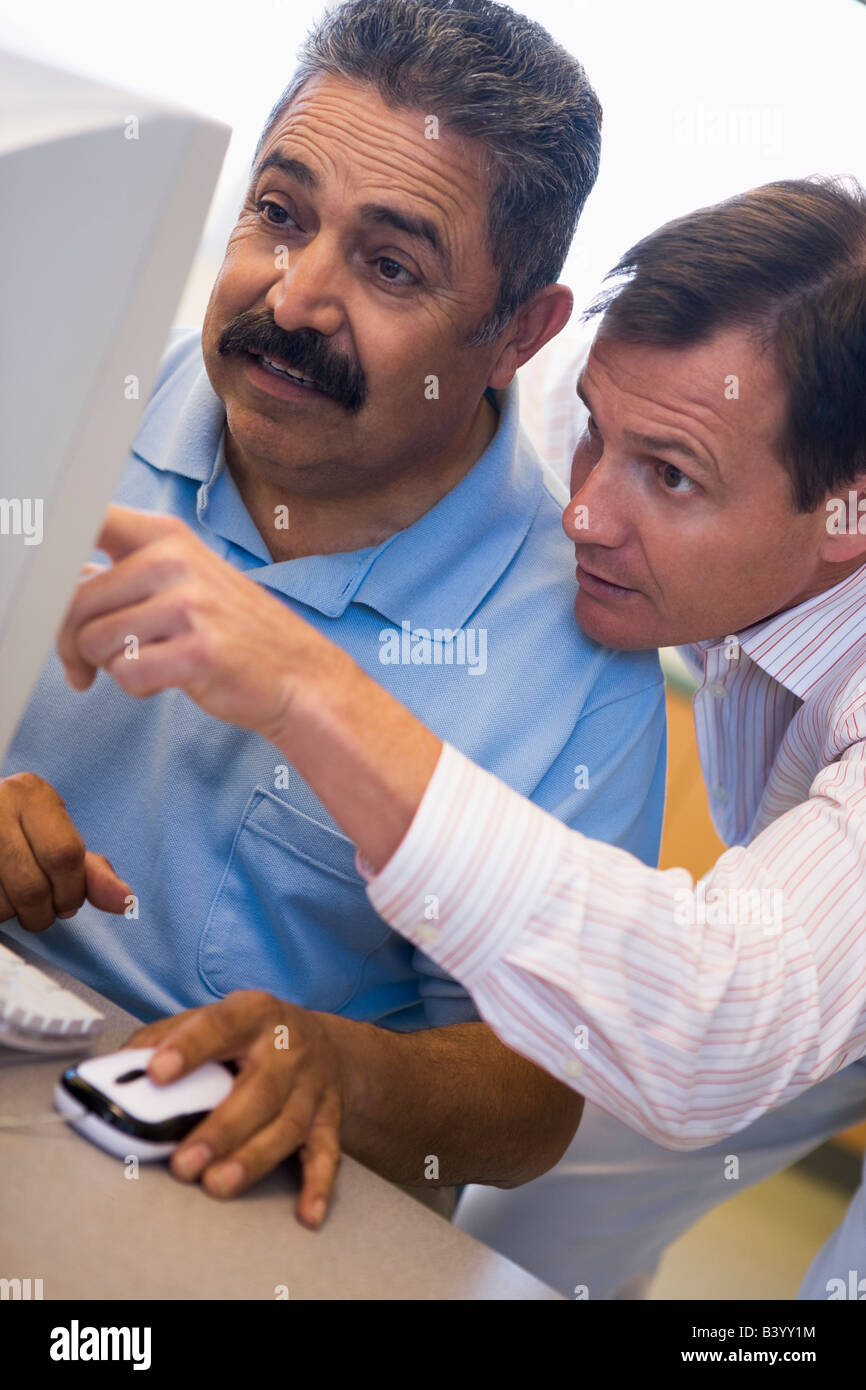 Two men at computer pointing at monitor (high key Stock Photo - Alamy