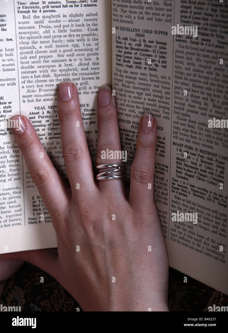A female hand holding back the pages of a book Stock Photo - Alamy
