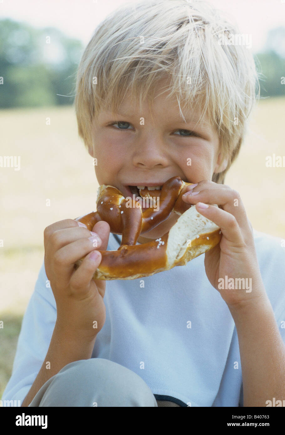 Boy (6-7 years) eating pretzel Stock Photo - Alamy