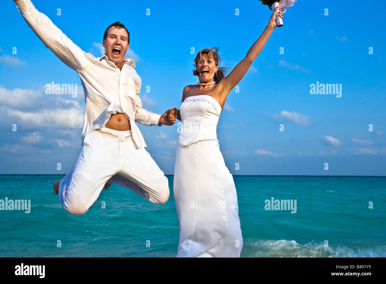 Wedding couple jumping on beach Stock Photo - Alamy