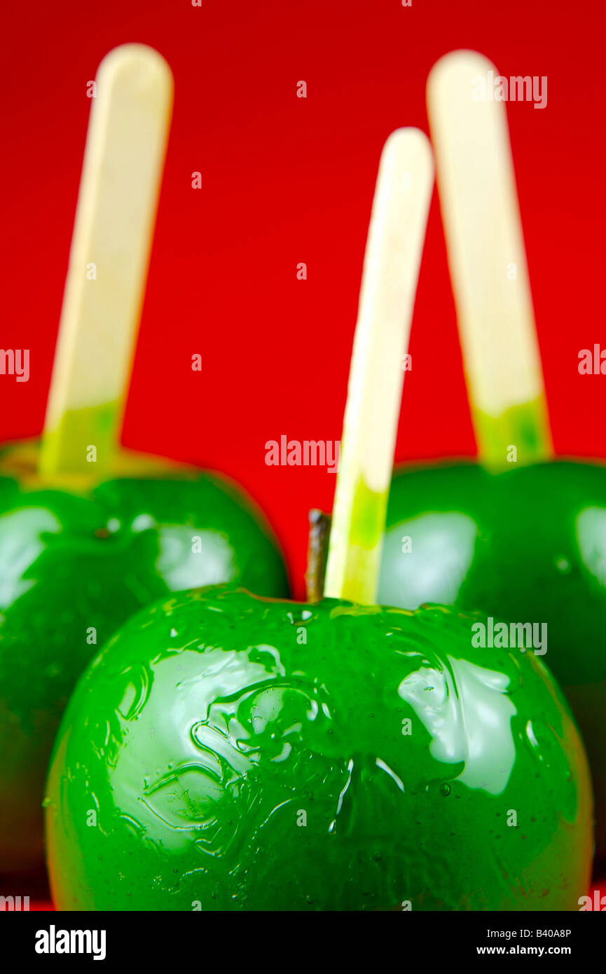 Toffee apples isolated against a red background Stock Photo - Alamy