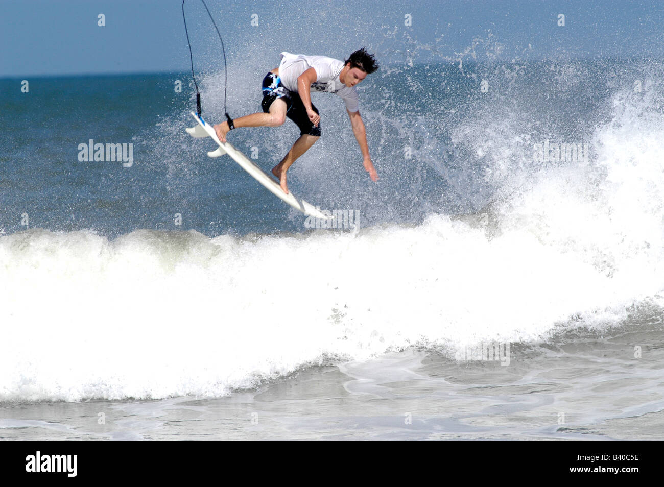 A surfer performs an aerial manouvre at Kuta Beach, Bali, Indonesia ...