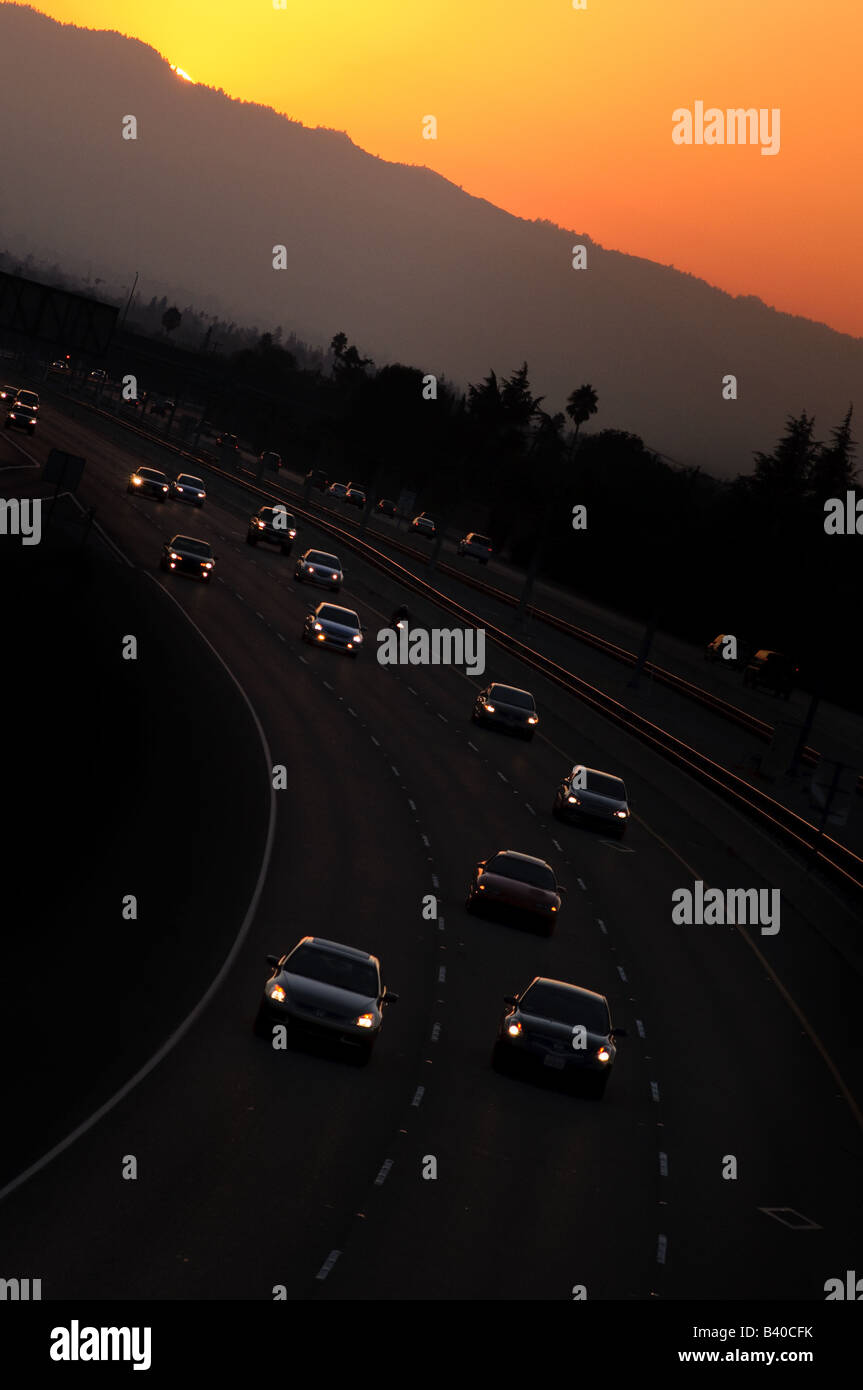 Freeway with cars empty lanes sunset over distant mountain range ...