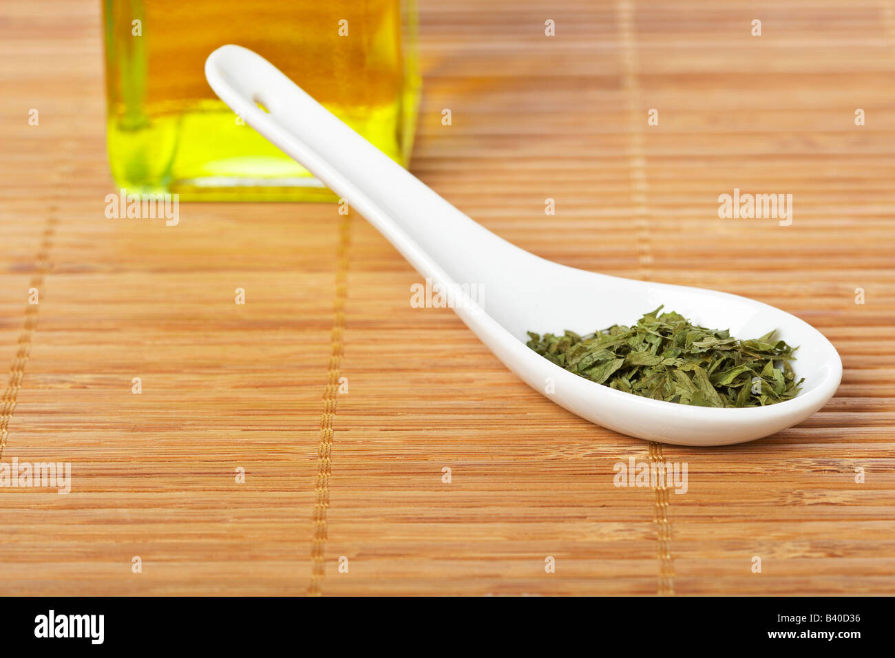 Parsley in the spoon and oil bottle for prepare tasty food with soft ...