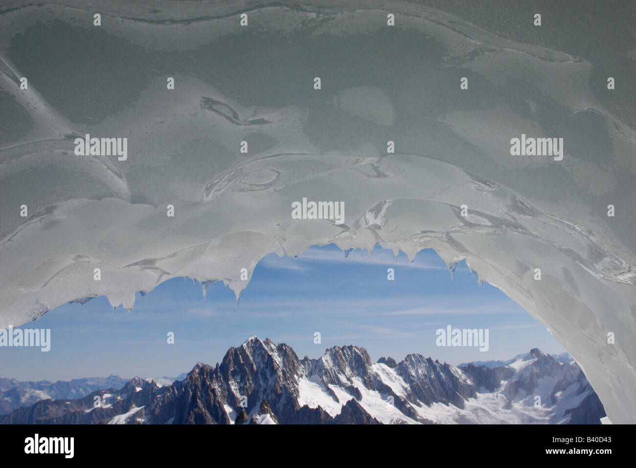 Arch of ice overlooking the Alps from the summit of the Aiguille du ...