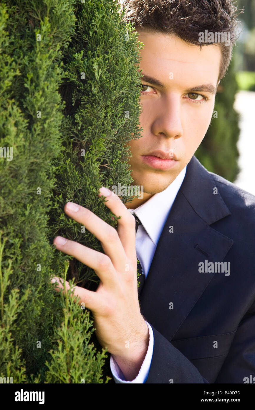 Businessman portrait behind green bush Stock Photo - Alamy