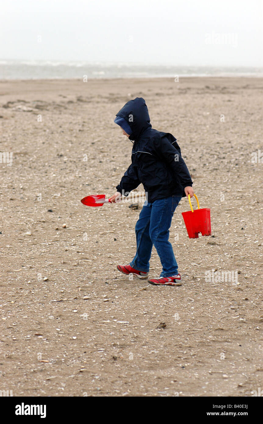 A boy beach combing in summer at Southport beach UK Stock Photo - Alamy