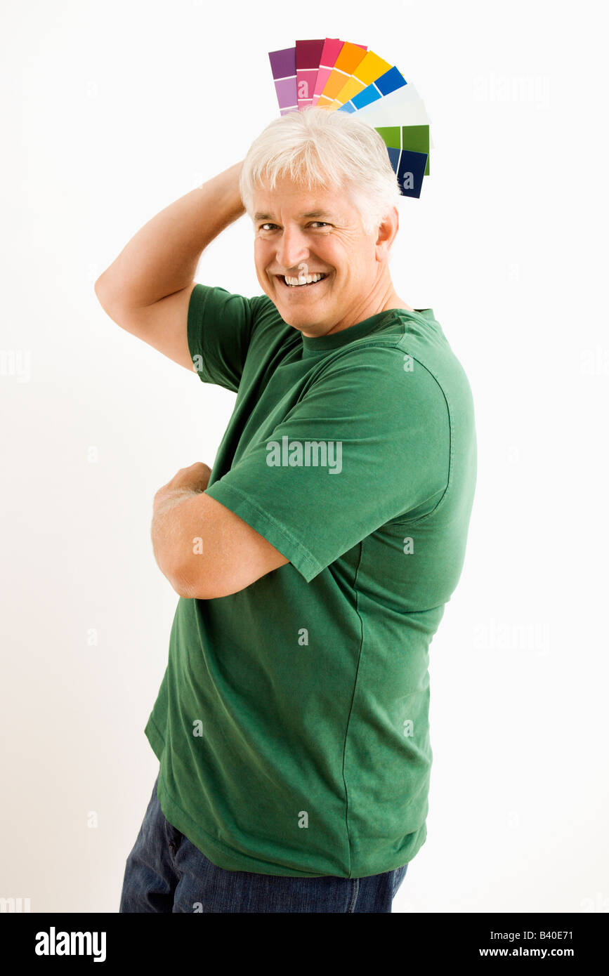 Middle aged man fanning paint swatches over his head Stock Photo - Alamy