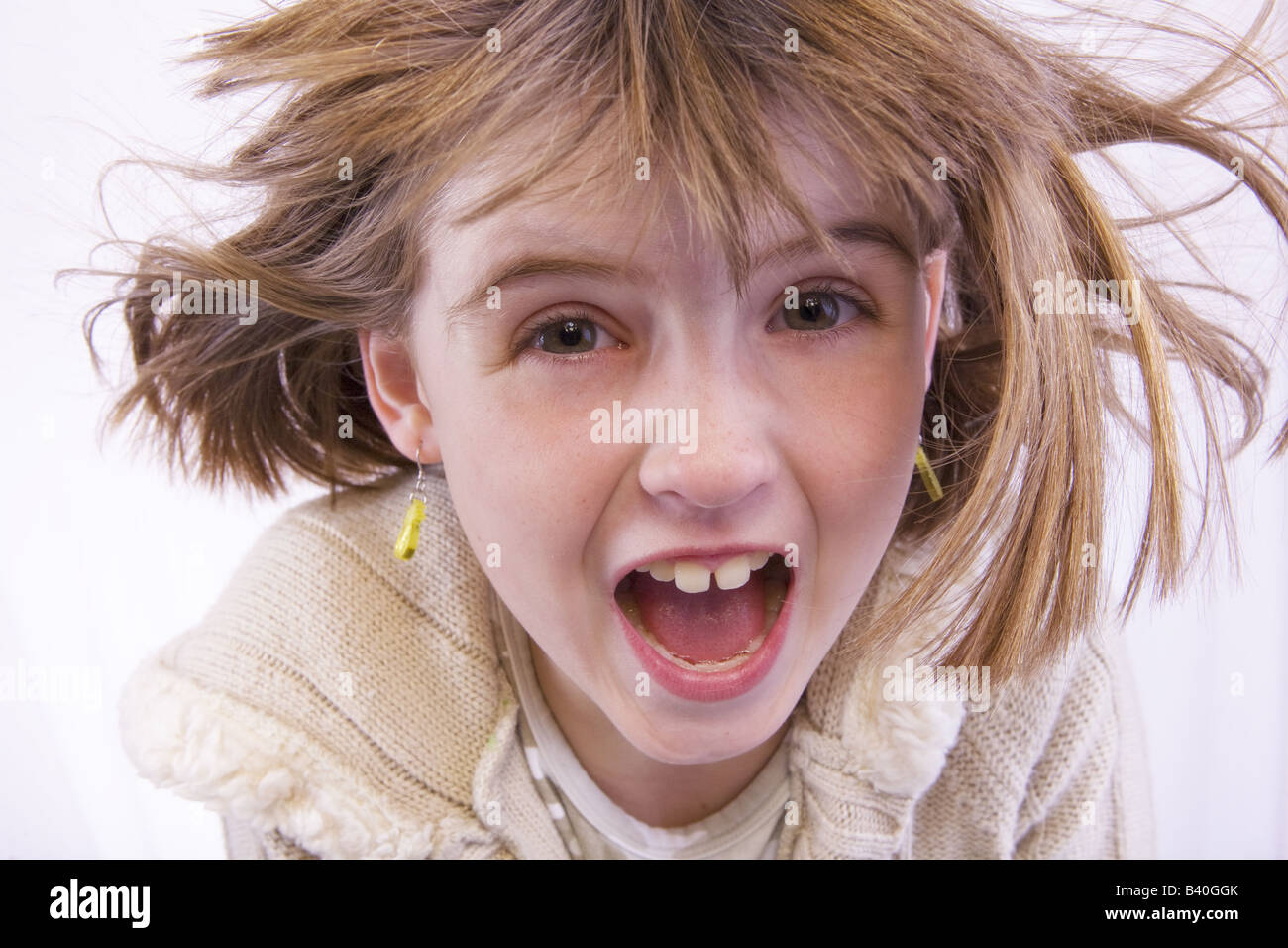 Terrified young girl with hair flying isolated on white background ...