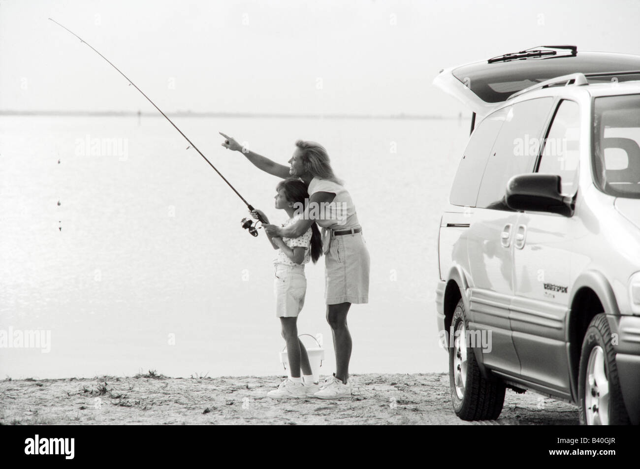 Mother and daughter together, mom teaching daughter to fish, laughing ...