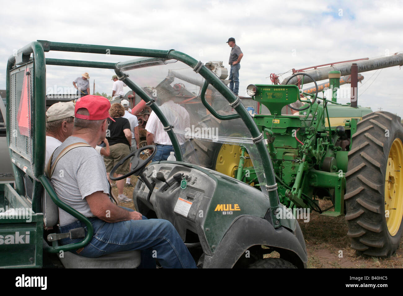 Old timers watch from a Mule farm utility vehicle at old time farm show ...