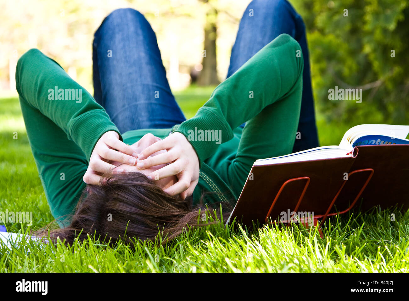 Exhausted student over the grass in the park Stock Photo - Alamy