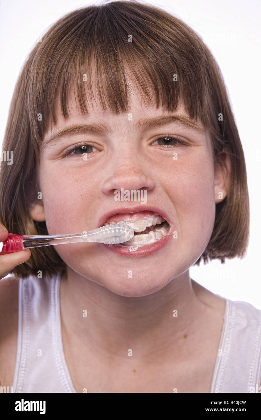 Young Brunette Girl Brushing Her Teeth Isolated On White Background