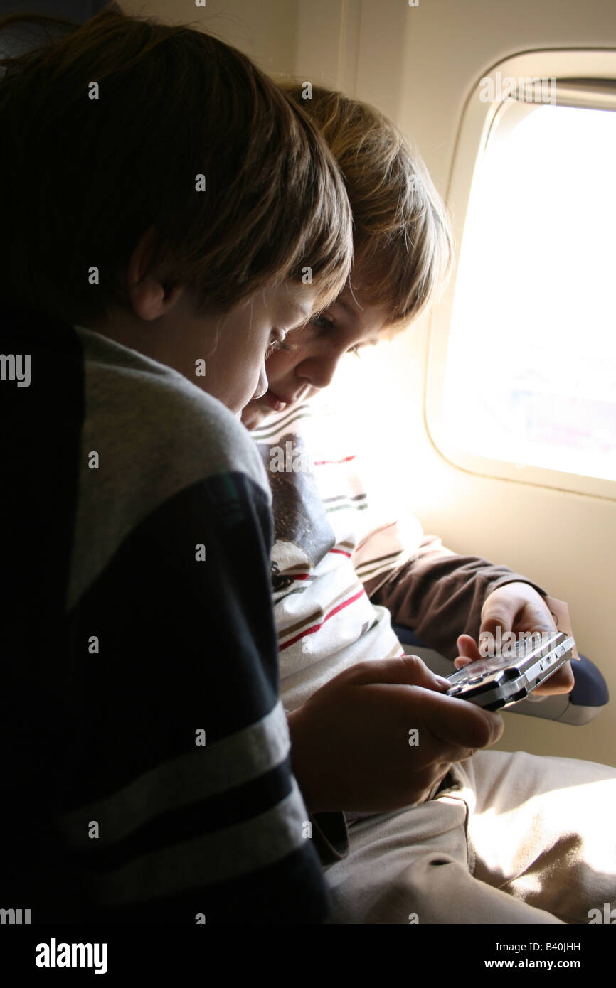 children playing play station portable psp game on an airplane Stock ...