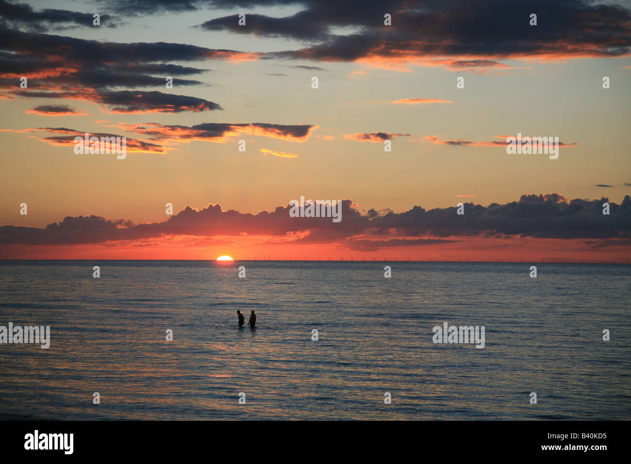 Two people swimming as sun sets Stock Photo - Alamy