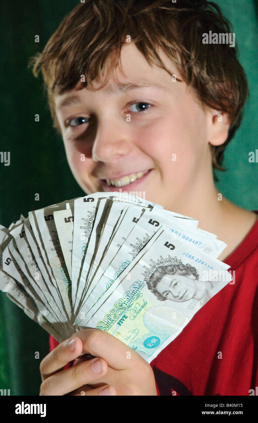 A teenage boy with a handful of british five pound notes Stock Photo ...