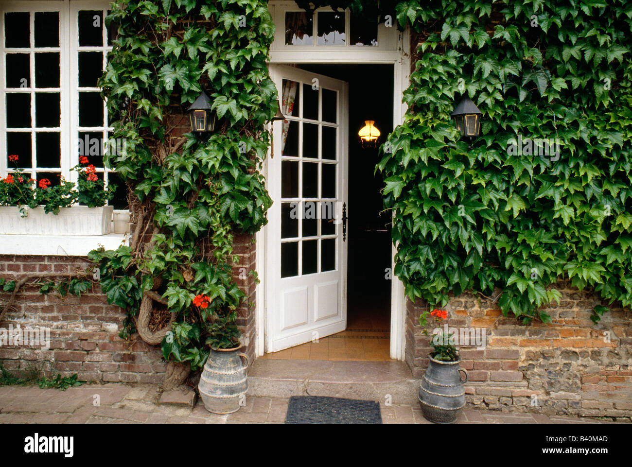 Ivy covered wall and front door to a country farm house, Normandy ...