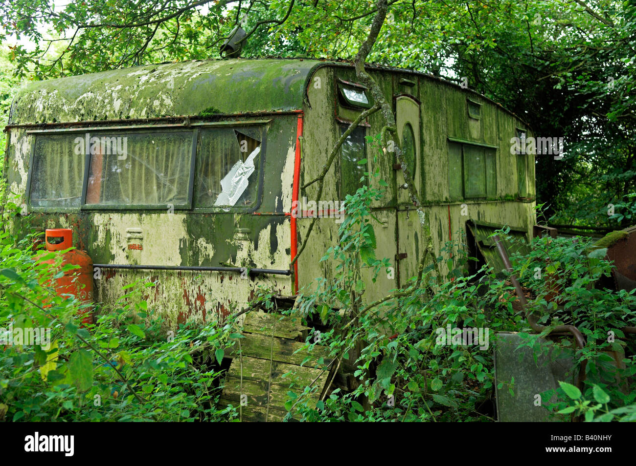 Derelict old caravan overgrown with weeds Stock Photo - Alamy