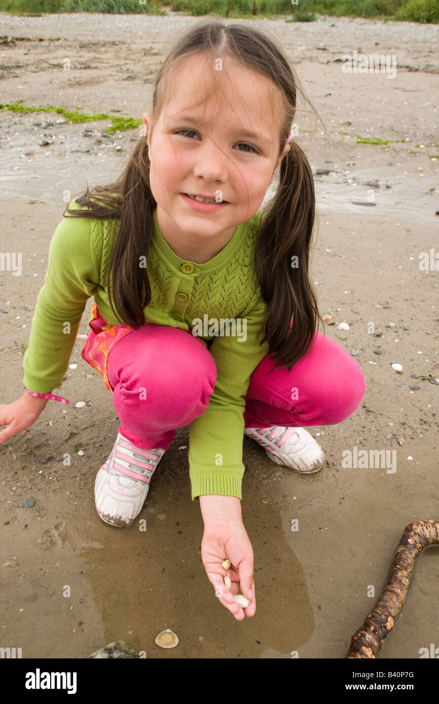 Young girl collecting pebbles on beach Stock Photo - Alamy