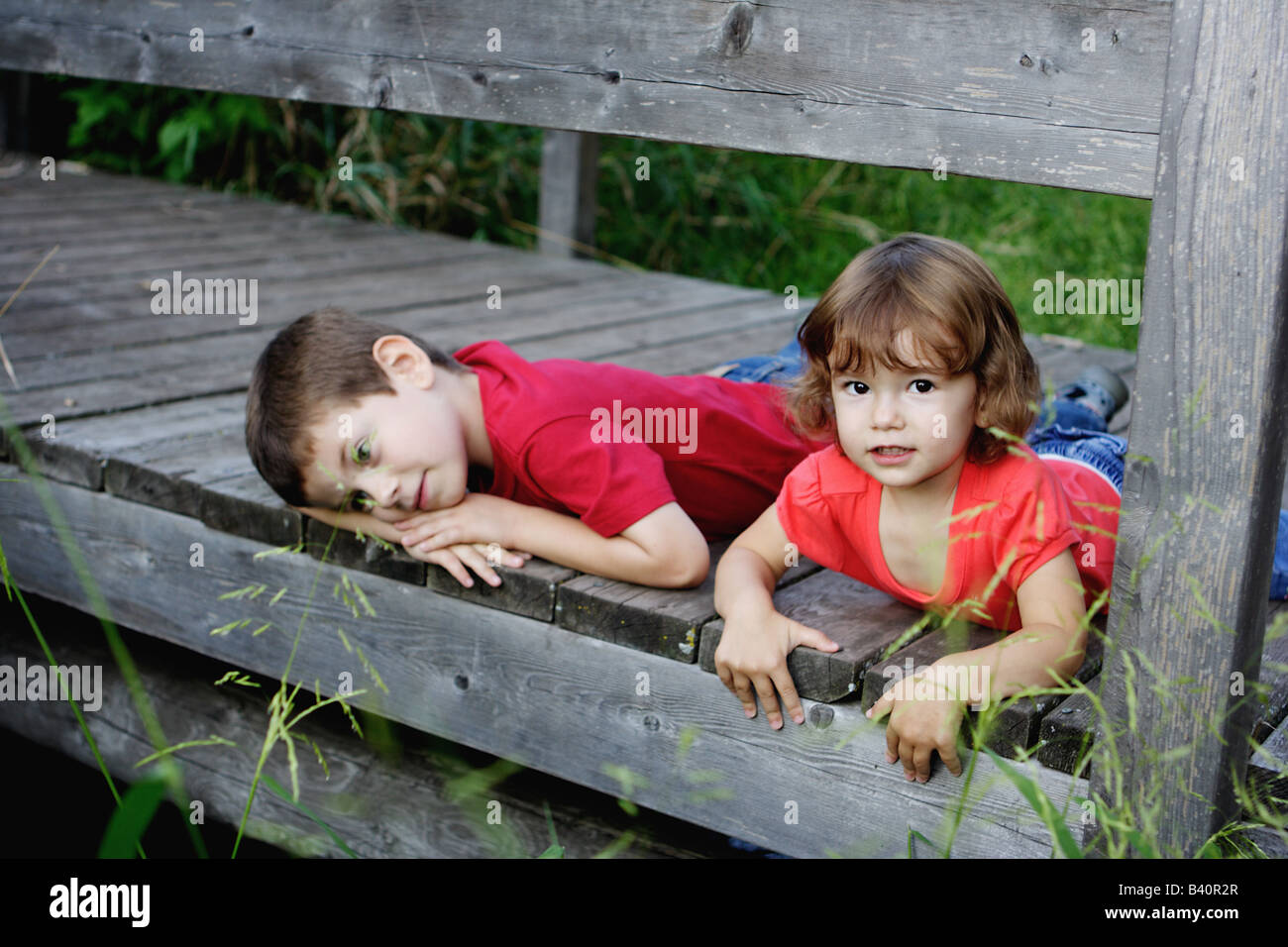 Four years old toddler boy and two years old toddler girl laying down ...