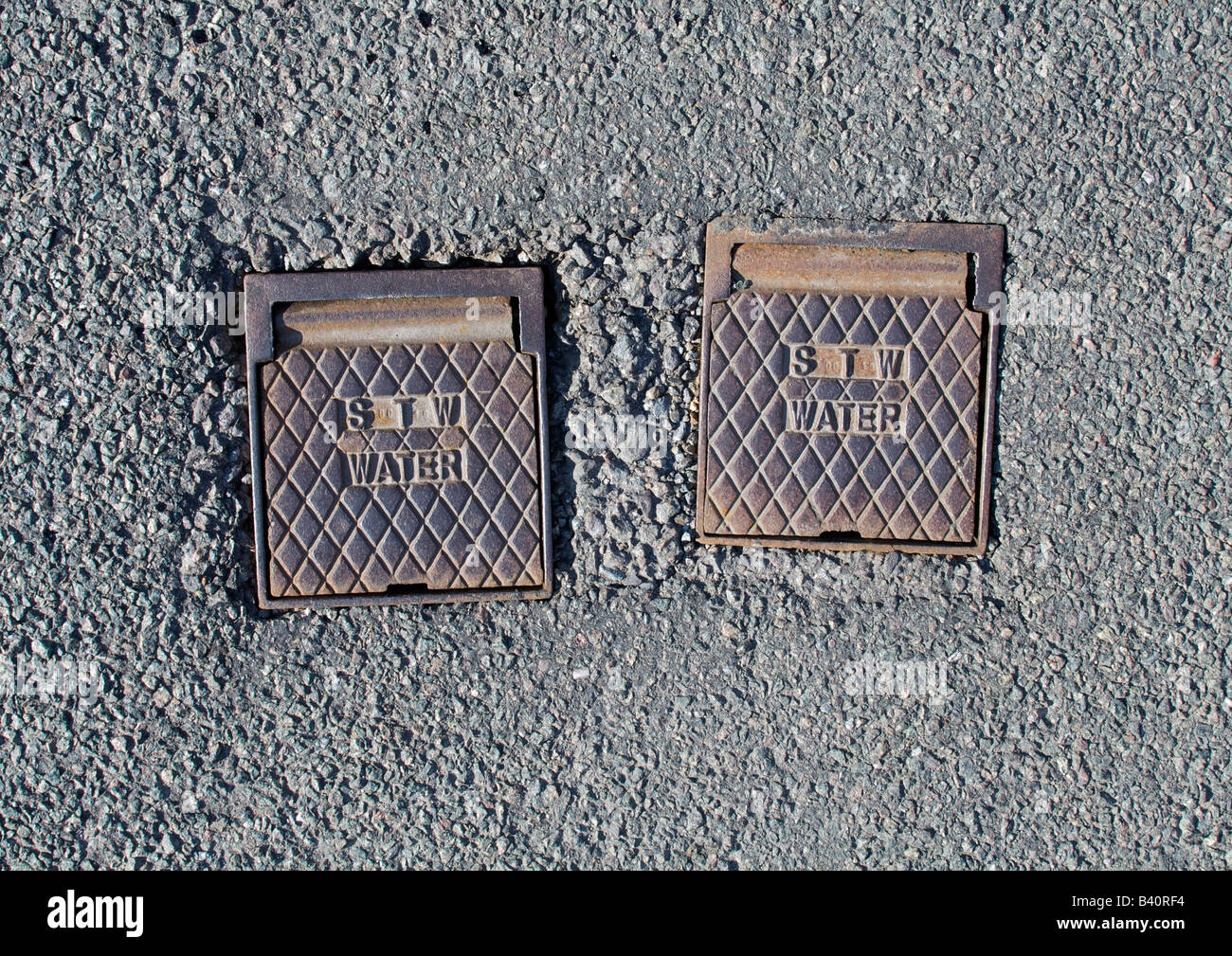 Two square cast iron covers for water stopcocks in the road Stock Photo ...