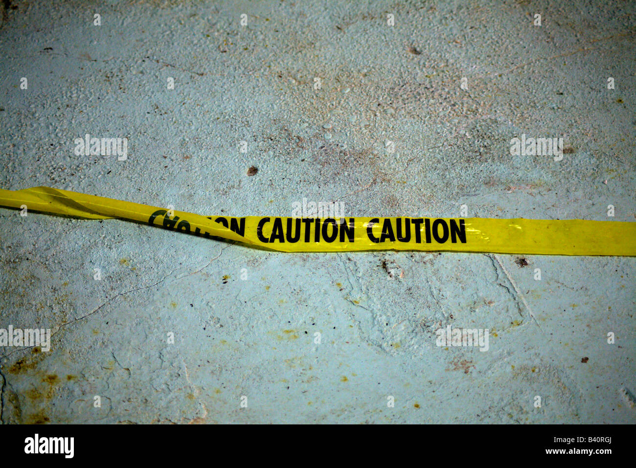 Caution tape laying on abandoned warehouse floor Stock Photo - Alamy