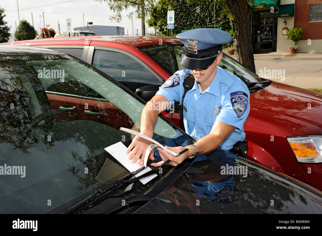 Police officer writes a ticket for parking violation Stock Photo - Alamy