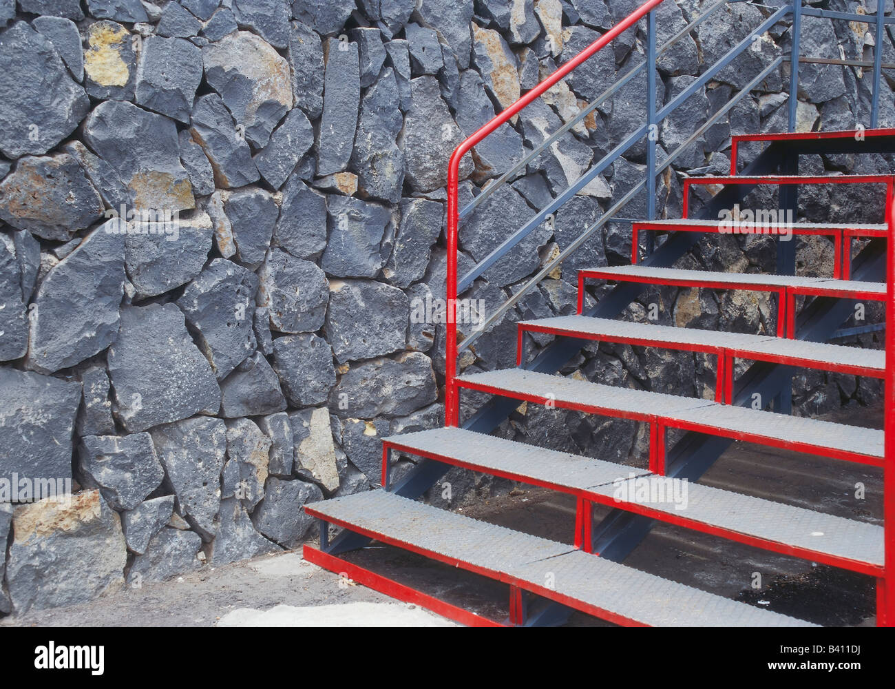 Metal staircase at stone wall Stock Photo - Alamy