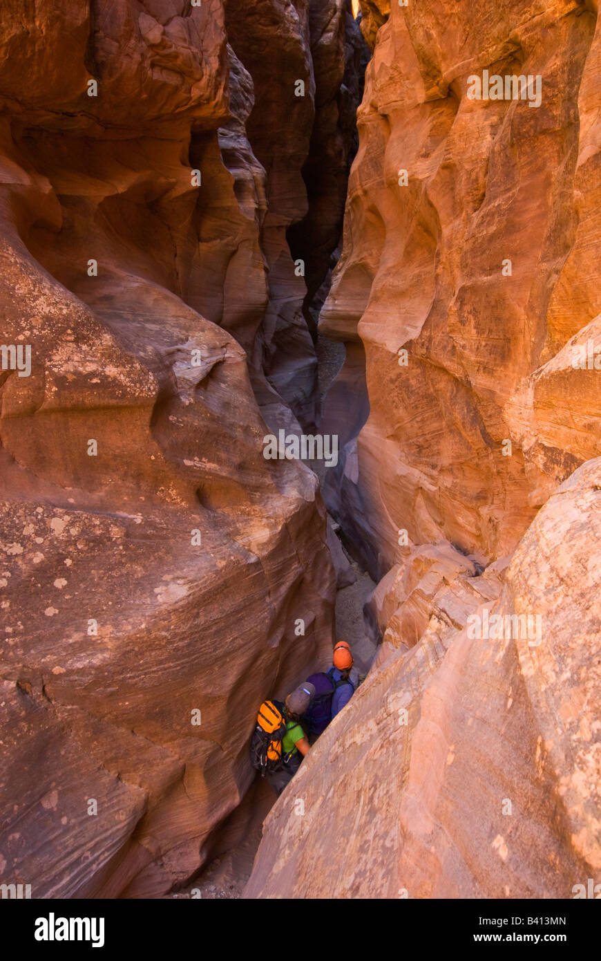 USA, Utah. Two female canyoneers walking along Chute Canyon on the San ...