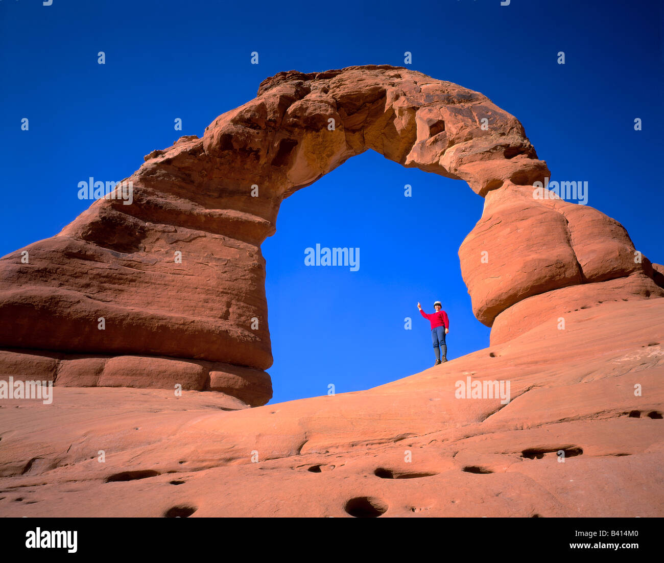 ARCHES NATIONAL PARK, UTAH. USA. Woman hiker below Delicate Arch. Model ...