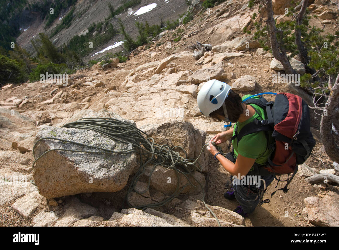 USA, Washington, Washington Pass. A female climber coils the rope ...