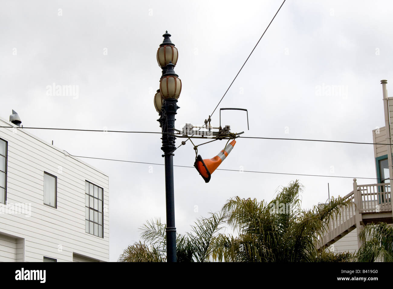 A traffic cone stuck in the wires of a street lamp Stock Photo - Alamy