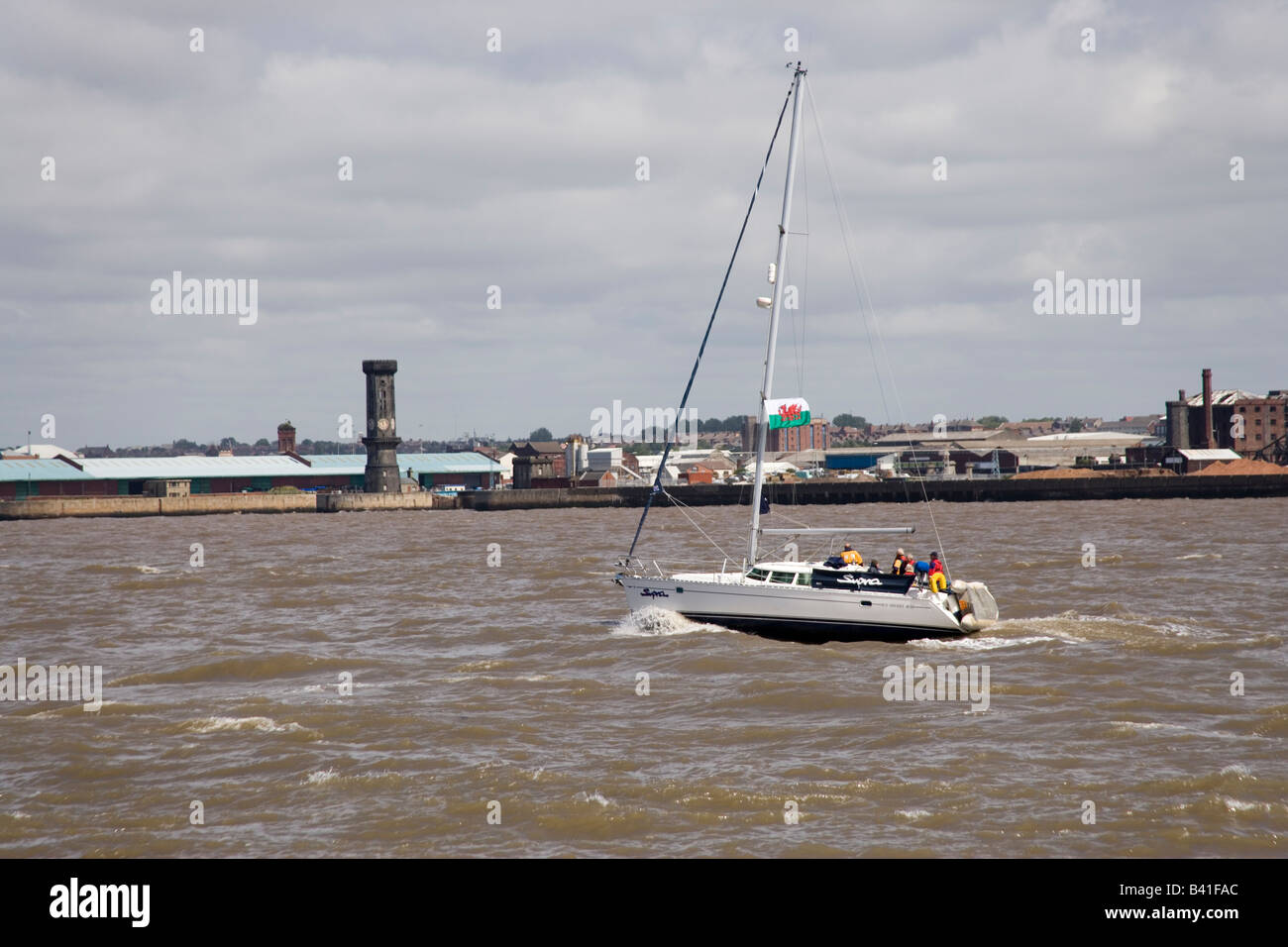Yacht sailing down the Mersey River with Liverpool behind, shot from ...