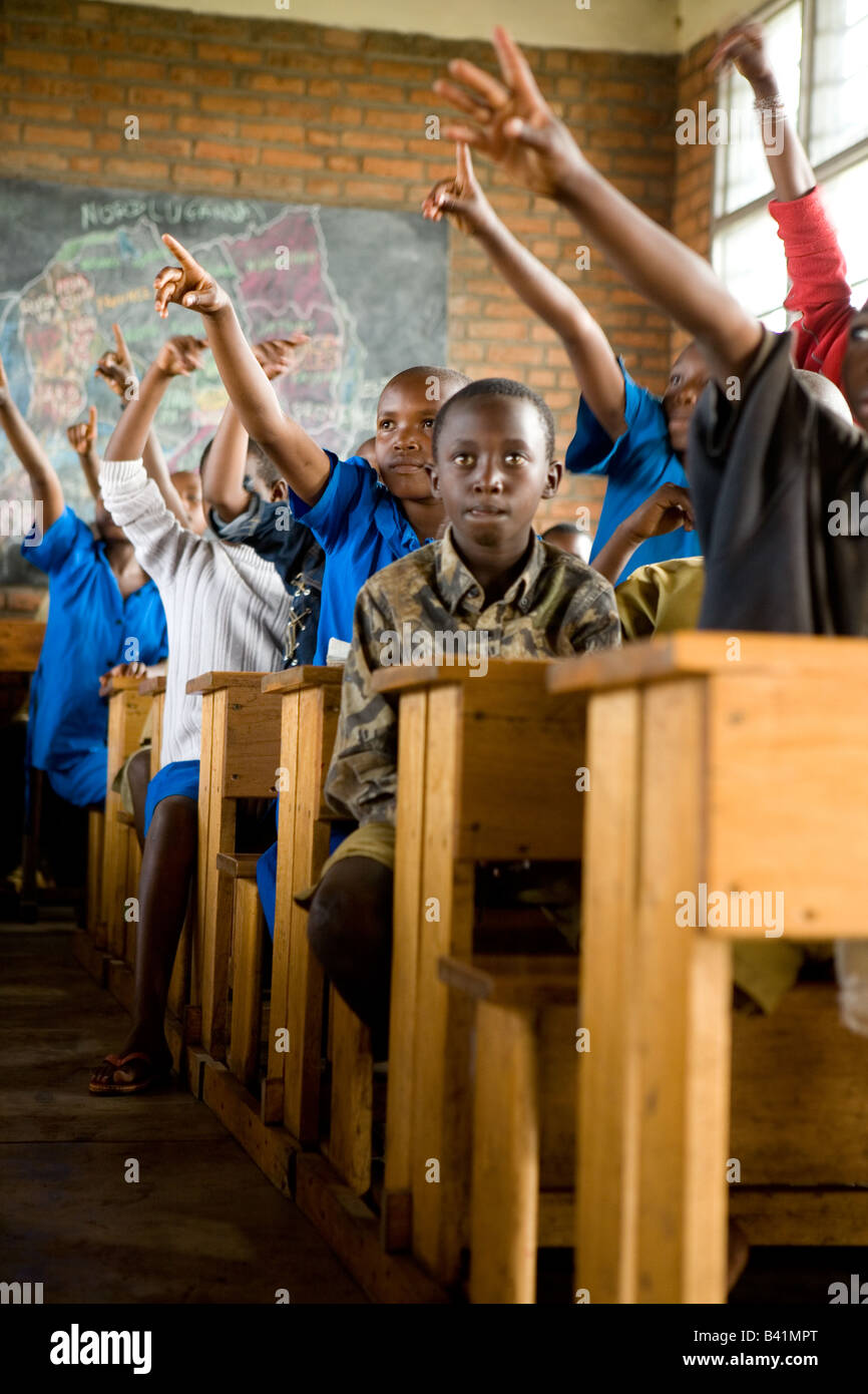 Rwanda students vigorously raise their hands to answer a teacher's ...