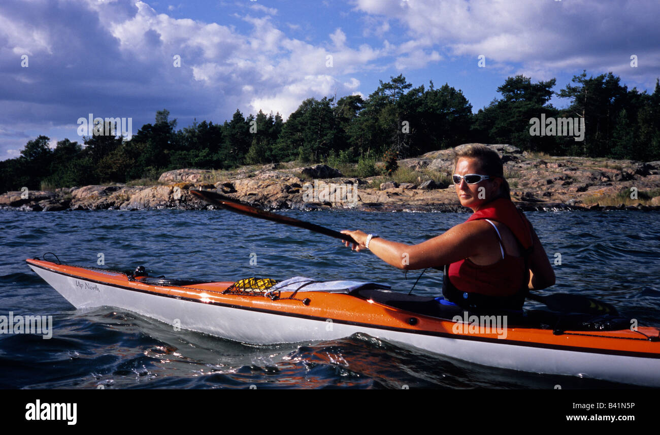 Younger woman kayaking in Swedish Baltic Sea Archipelago near Nykoping ...