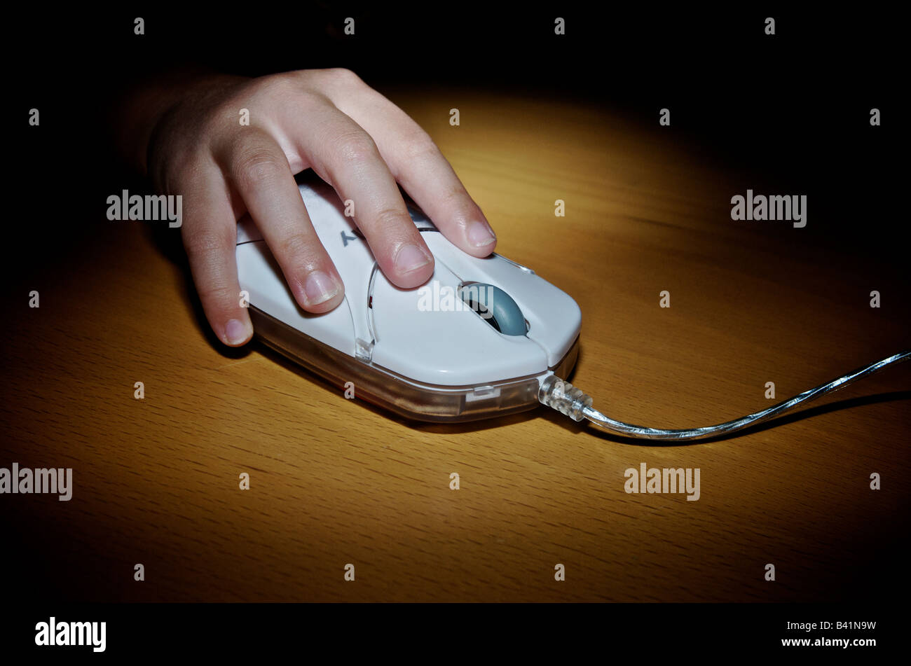 child's hand holding a computer mouse on a wooden tabletop Stock Photo ...