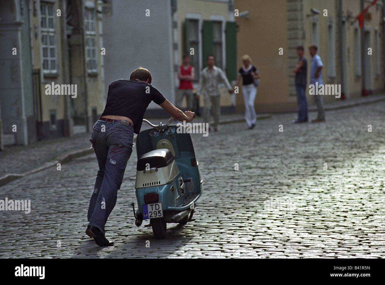 Young man pushing his motorbike, Riga, Latvia Stock Photo - Alamy